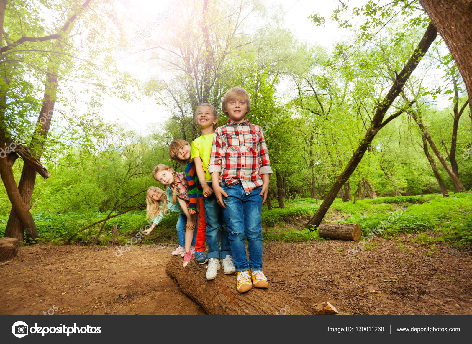 Kids standing on log Stock Photo by ©serrnovik 130011260