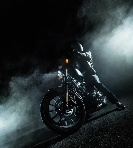 Close-up of high power motorcycle chopper with man rider at night ...