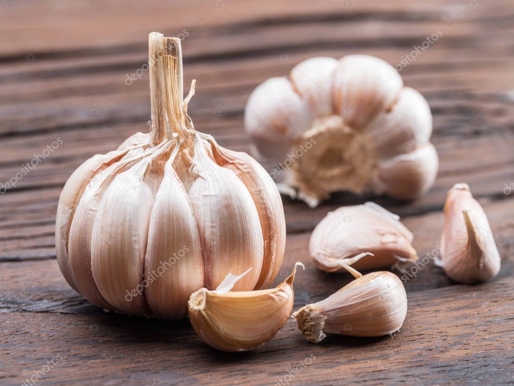 Bulbo de ajo y dientes de ajo en la mesa de madera. 2025