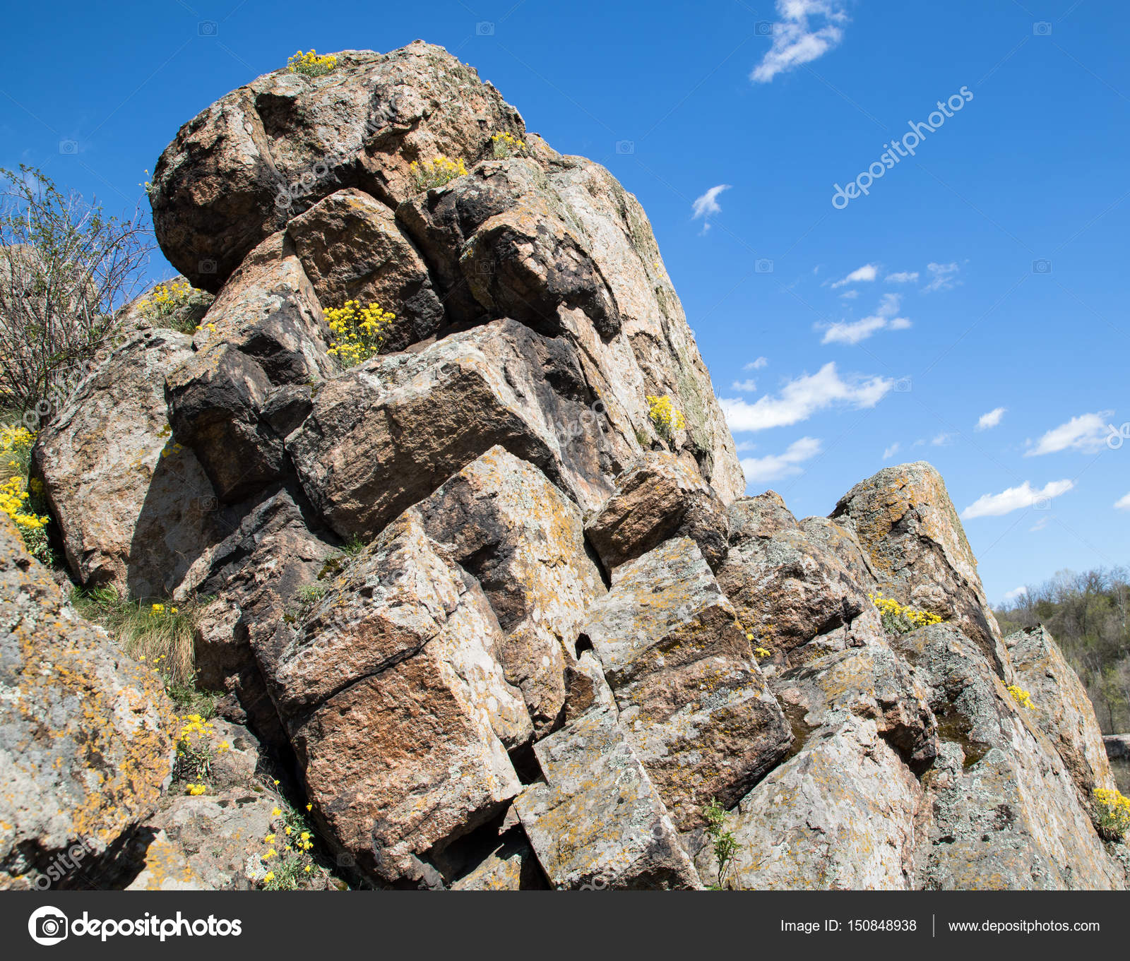 Close-up view cascade of stones on the rock, blue sky on the background ...