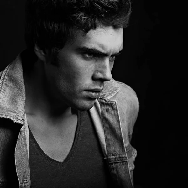 Sexy serious thinking male model posing in blue jacket on dark s Stock ...