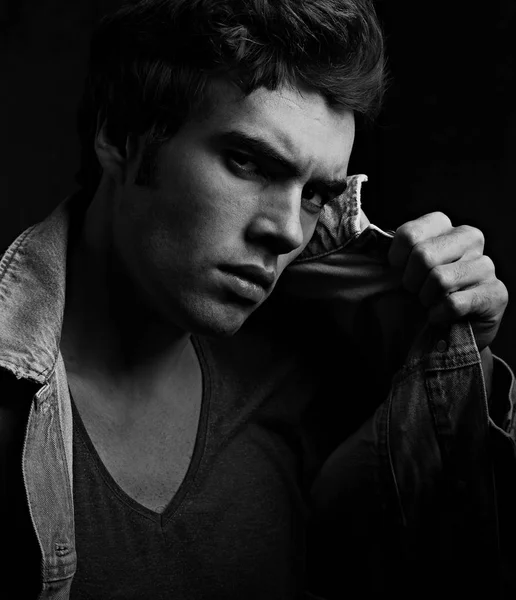 Sexy serious thinking male model posing in blue jacket on dark s Stock ...