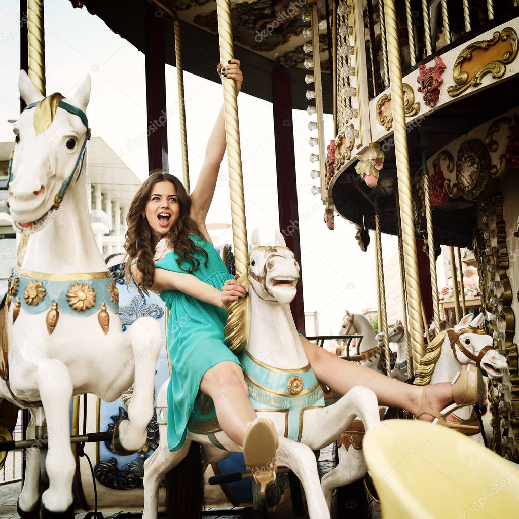 Happy woman on carousel Stock Photo by ©khorzhevska 129357458
