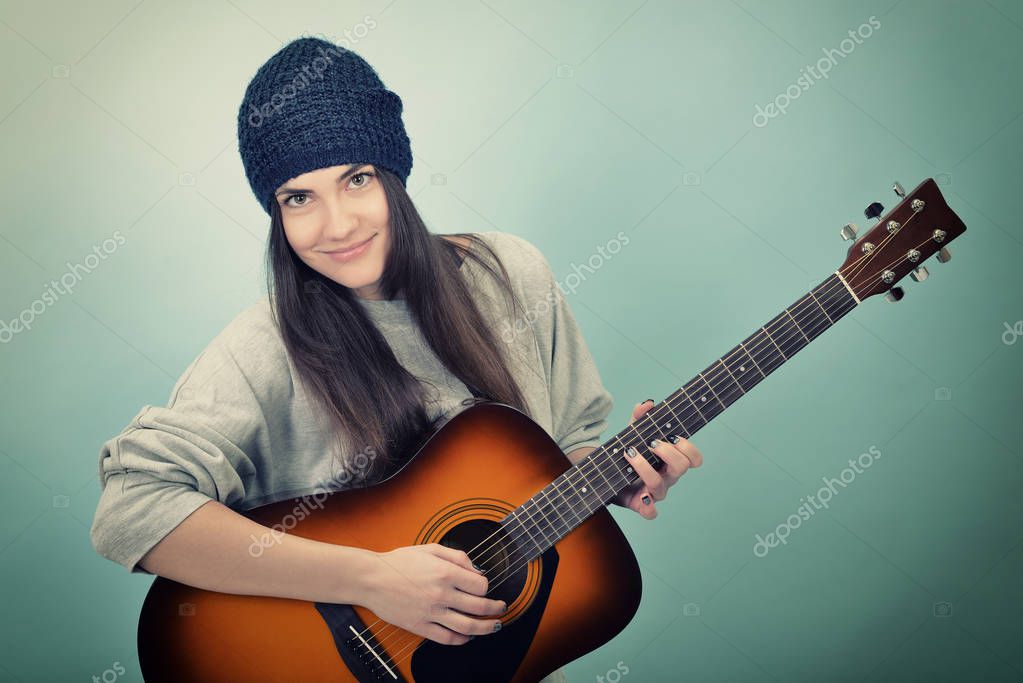Woman playing music on guitar Stock Photo by ©khorzhevska 129367546