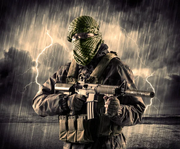 Dangerous armed terrorist with mask and gun in a thunderstorm wi Stock ...