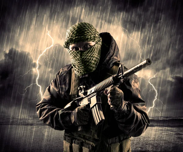 Dangerous armed terrorist with mask and gun in a thunderstorm wi Stock ...