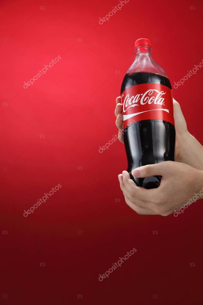 Las manos sostienen la Coca-Cola 2024
