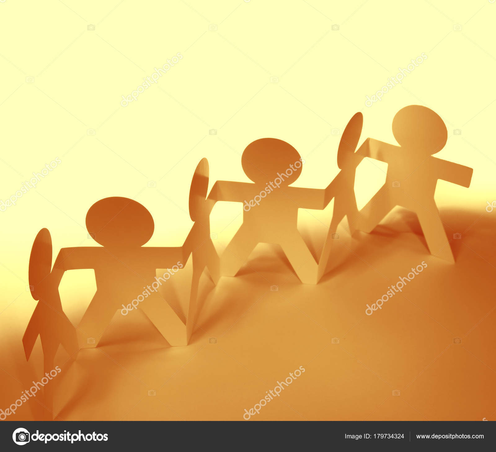 Paper chain team holding hands Stock Photo by ©stillfx 179734324