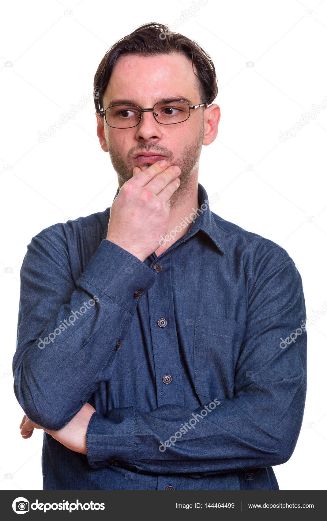 Studio shot of formal young man thinking while wearing eyeglasse ...