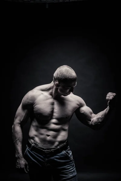 portrait of a male bodybuilder, straining muscles in sports pose ...