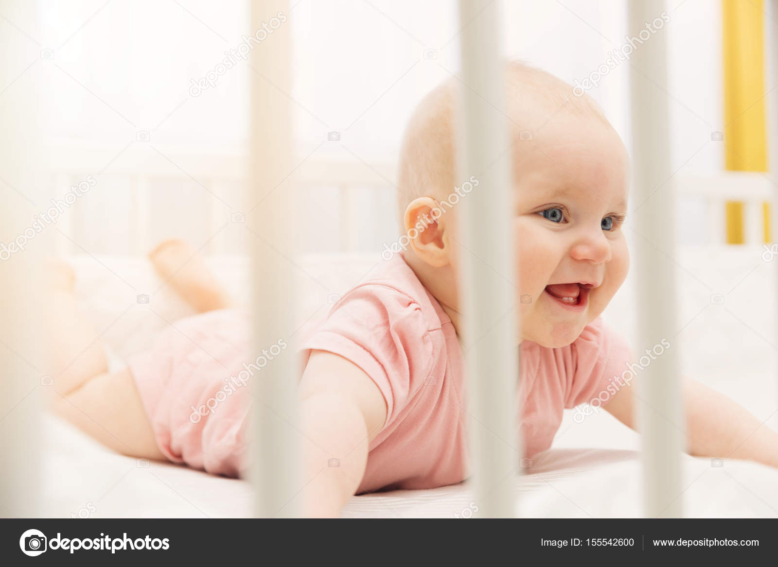 Cute happy baby girl playing in crib — Stock Photo © ronstik #155542600