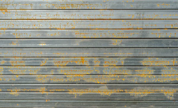 Racks of metal profiles. Metal is stored in an open warehouse. Wet and ...