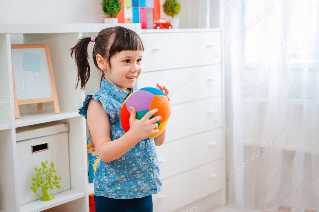 niños niña pequeña jugar en una sala de juegos para niños, lanzando pelota. concepto de ...