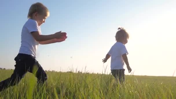 Happy family catch-up kids concept. little boy and girl run on green ...