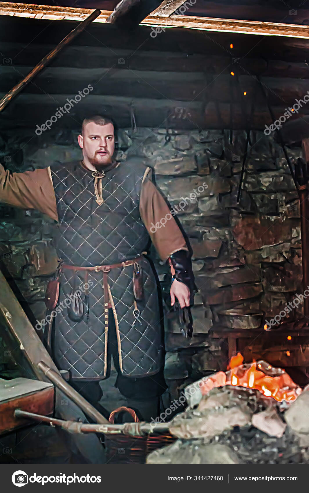 A blacksmith in a medieval forge, Historical reconstruction of t ...