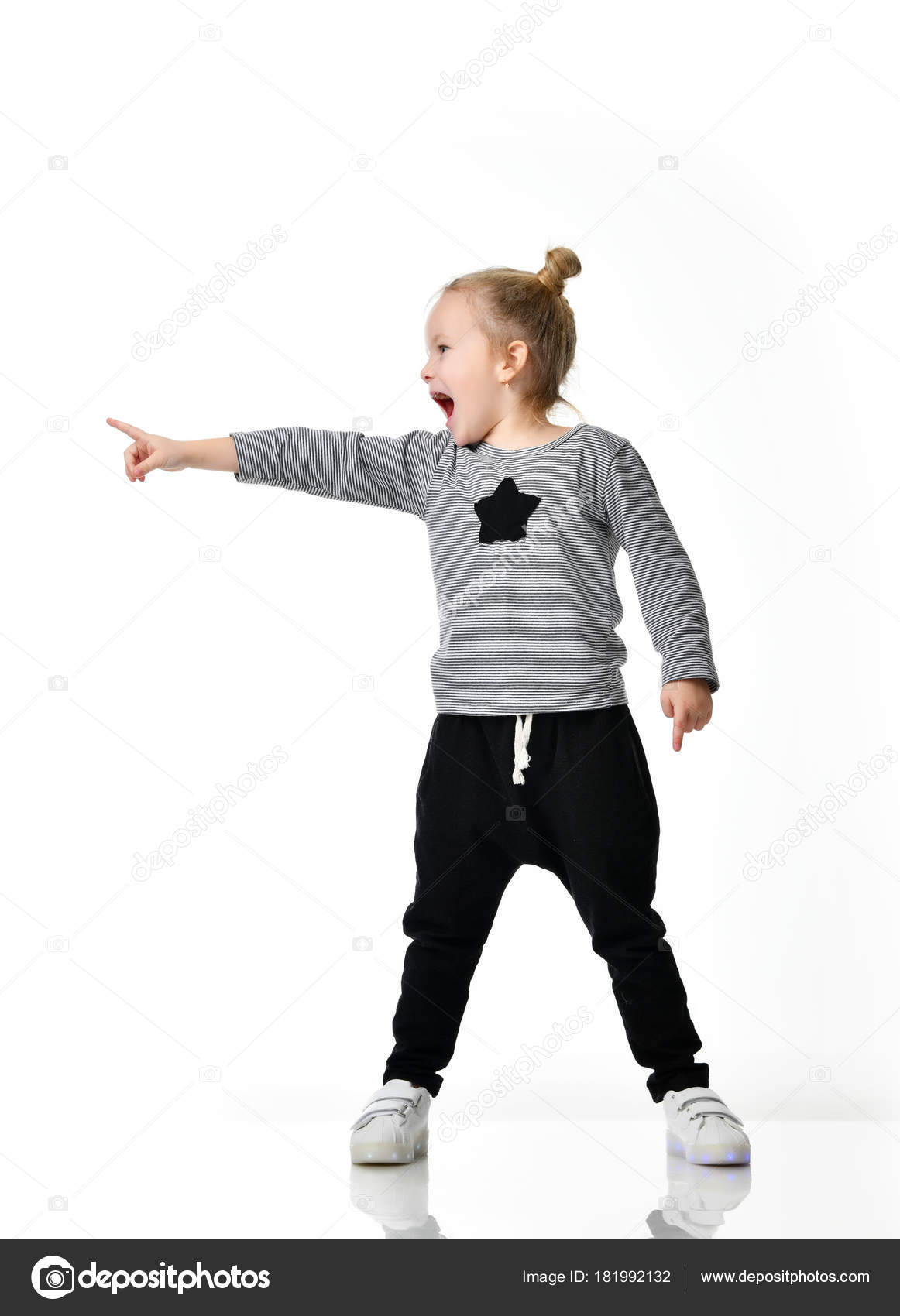 Young girl kid surprised yelling shouting pointing finger at the corner ...