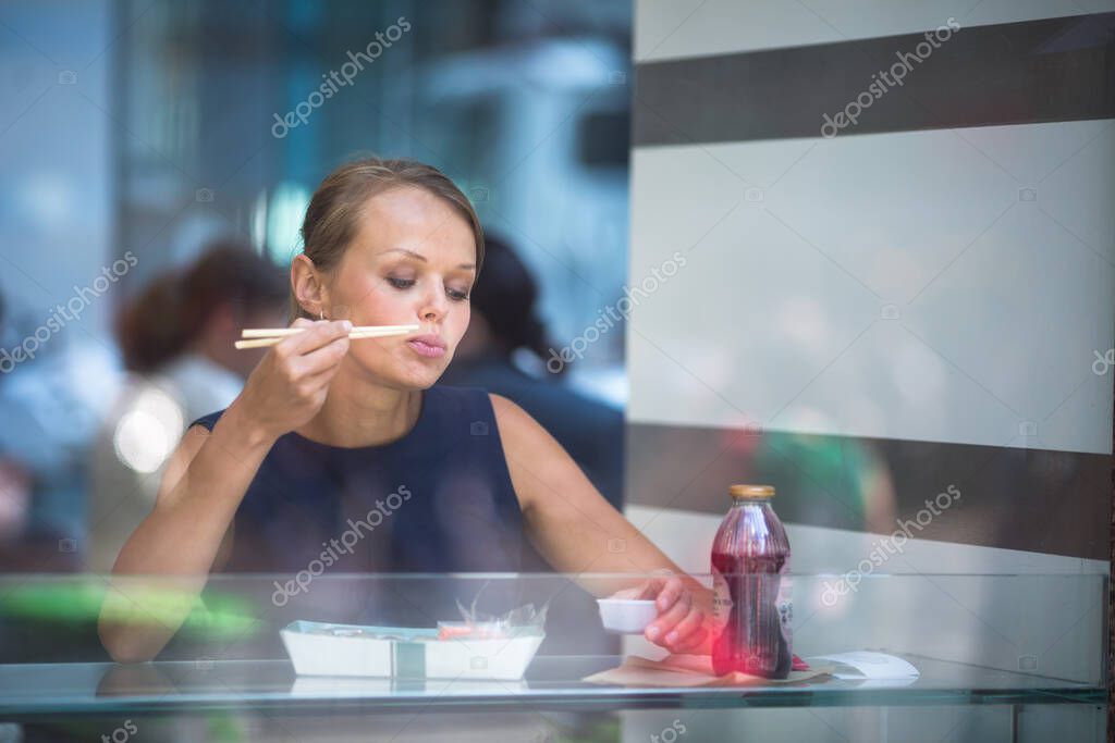 Mujer bonita y joven comiendo sushi en un restaurante, almorzando ...
