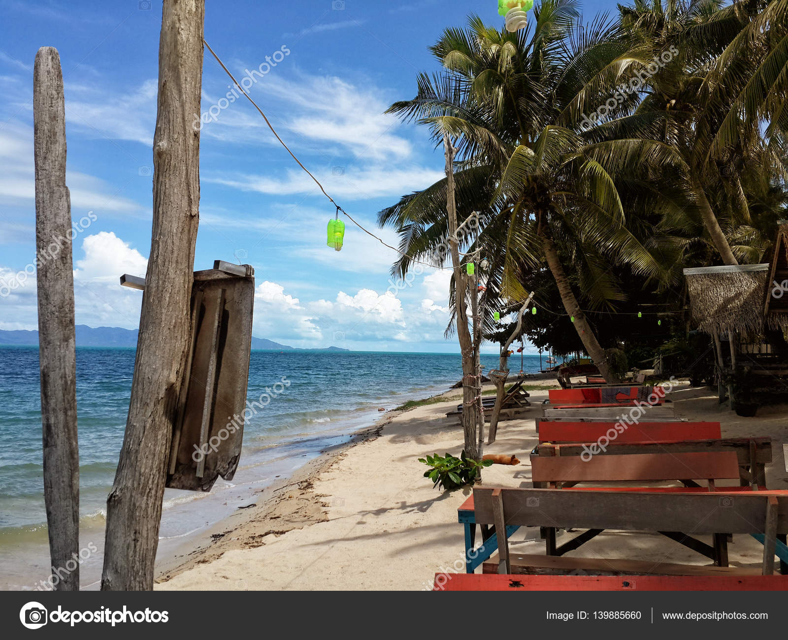 Wooden cafe tables on sandy sea coast with palm trees. Island Koh Samui ...