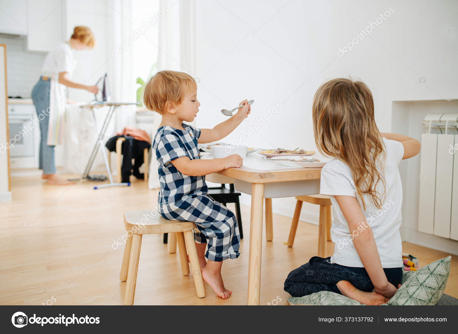 Children Eating Small Table Mom Ironing Clothes Blurred Background ...