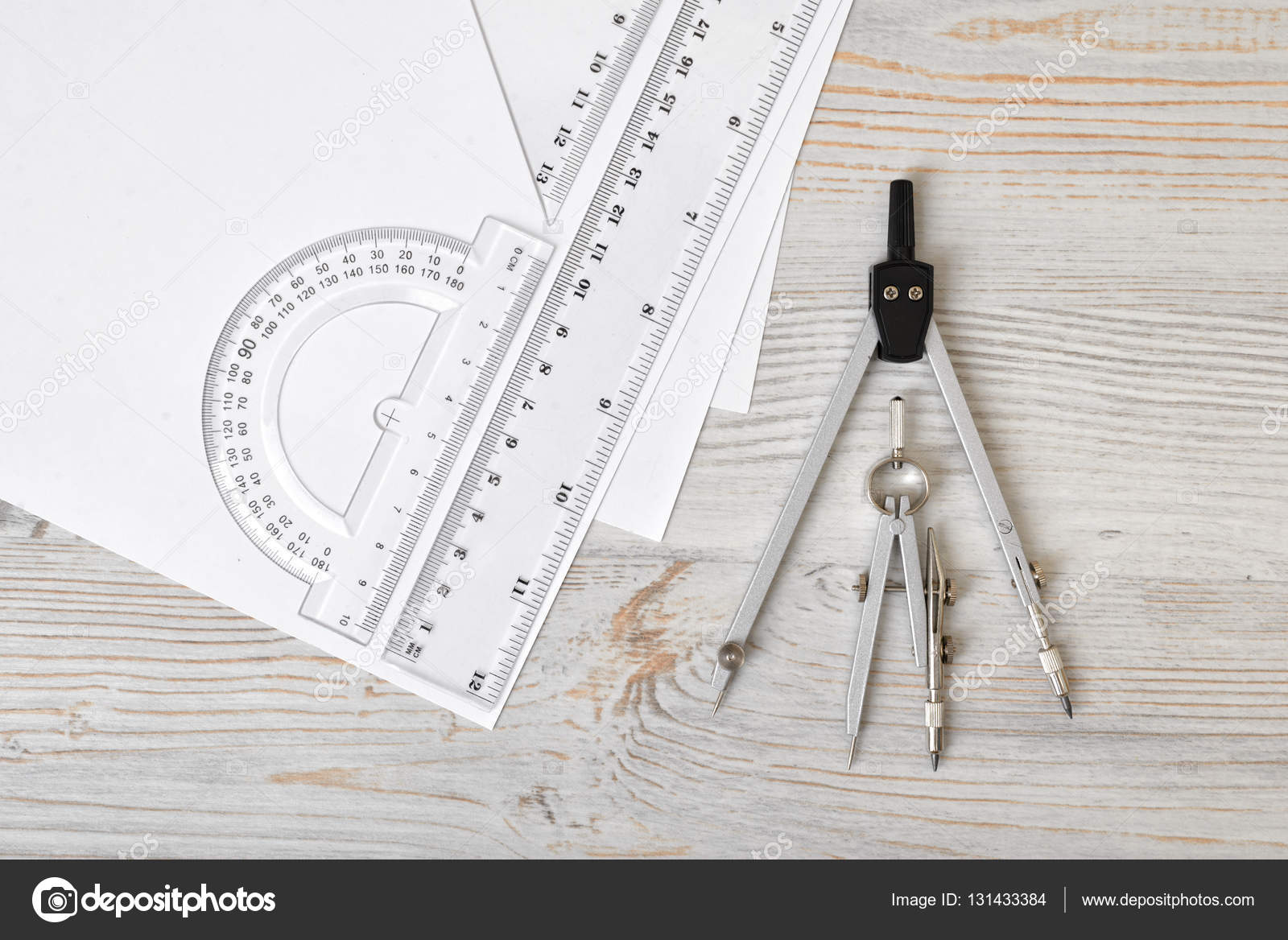 Layout with compass, protractor and centimeter ruler on wooden surface ...