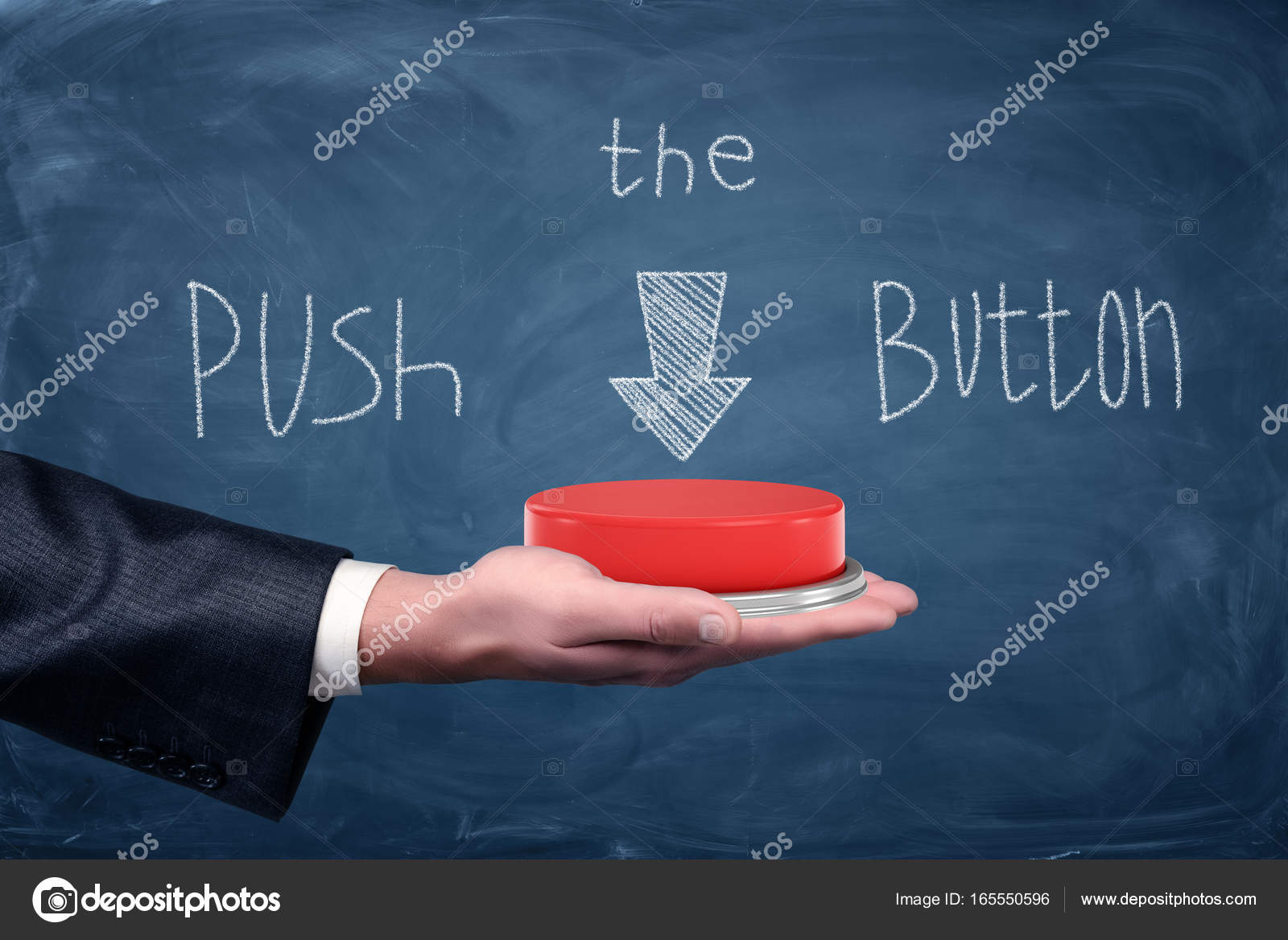 A large red push button resting on businessmans palm under a chalkboard ...