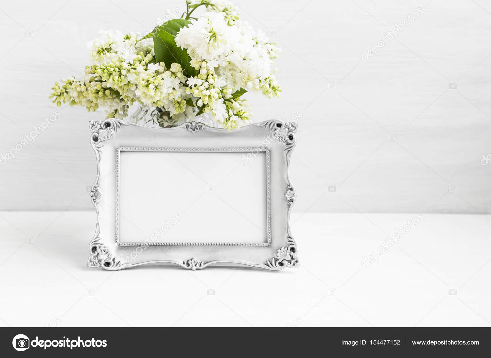 Vintage silver photo frame with lilac flowers on white still lif ...
