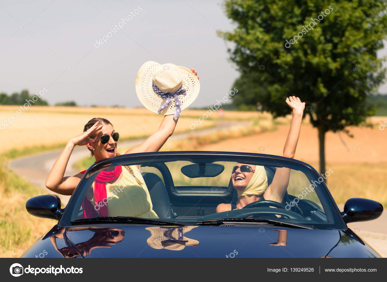 Friends having summer joyride in convertible car — Stock Photo © Kzenon ...