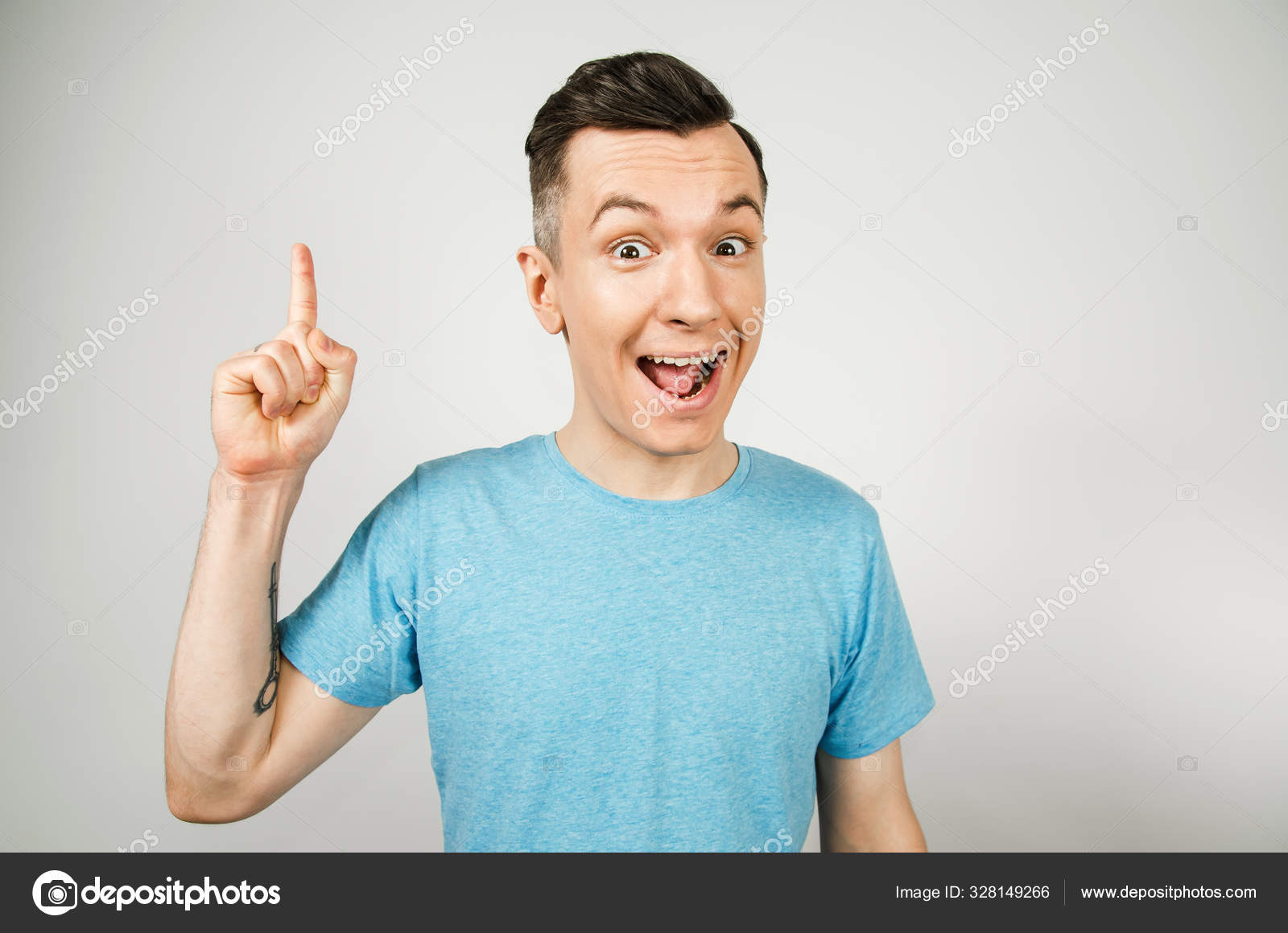 Idea Joven chico sonriente con el dedo en alto, vestido con una ...