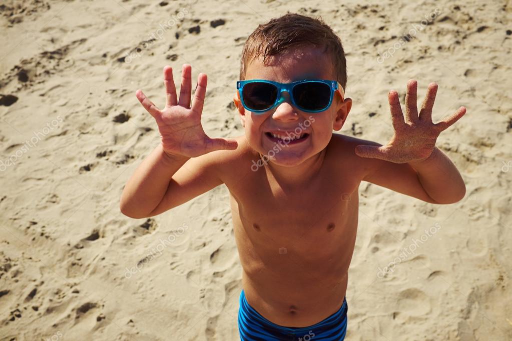 A lively boy in sunglasses smiling at the camera on the beach ⬇ Stock ...