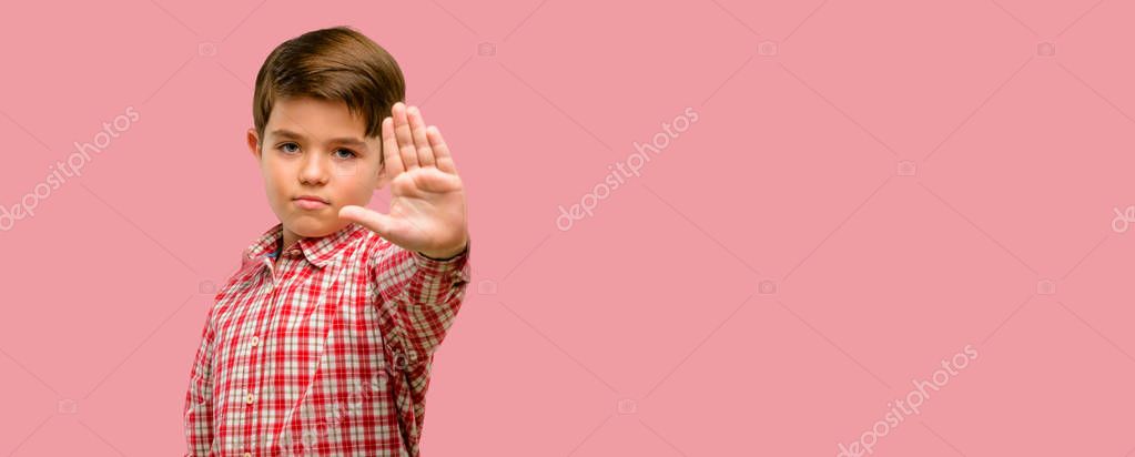 Niño guapo con ojos verdes molesto con mala actitud haciendo señal de ...