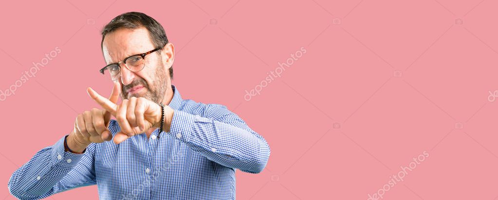 Guapo hombre de mediana edad molesto con mala actitud haciendo señal de ...