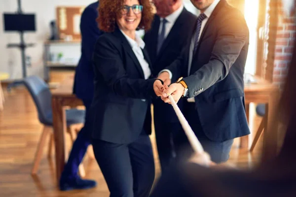 Business workers stretching rope at the office - Stock Image - Everypixel