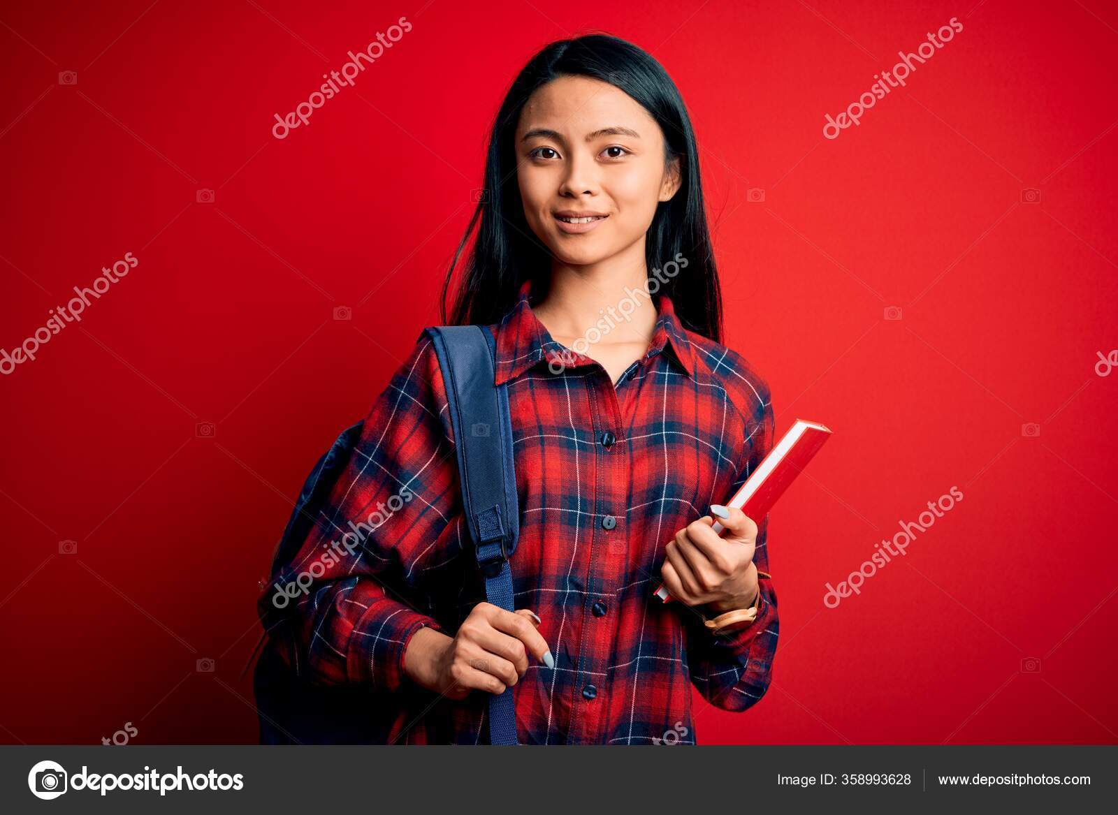 Young Beautiful Chinese Student Woman Holding Book Standing Isolated ...