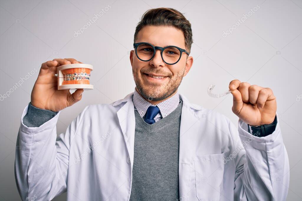 Médico dentista profesional sonriendo y sosteniendo la dentadura ...