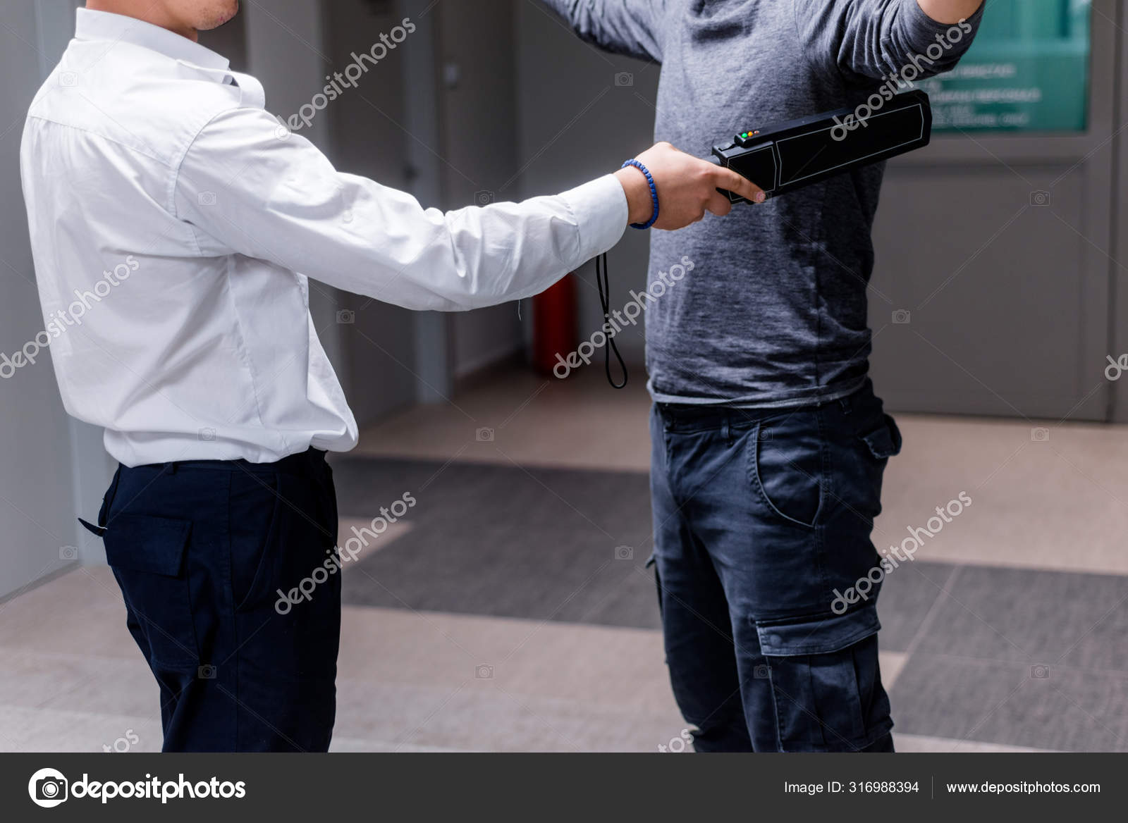 Security guard checking a man for weapons at entry Stock Photo by ...