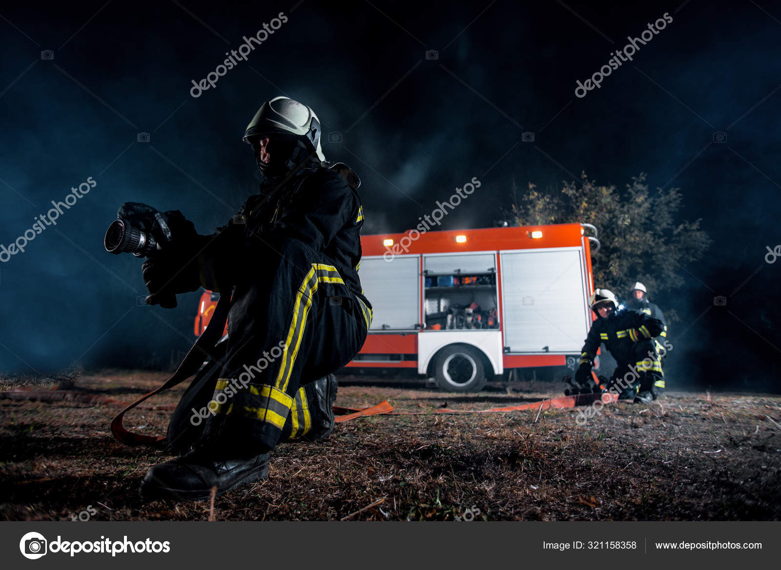 Firefighting crew at a fire scene Stock Photo by ©gorgev 321158358