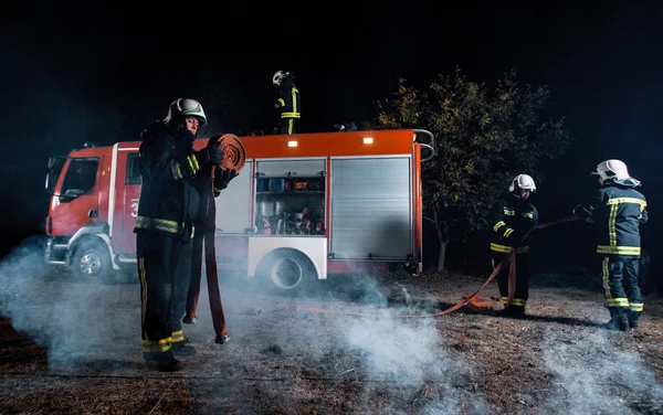 Firefighting crew at a fire scene Stock Photo by ©gorgev 321158358