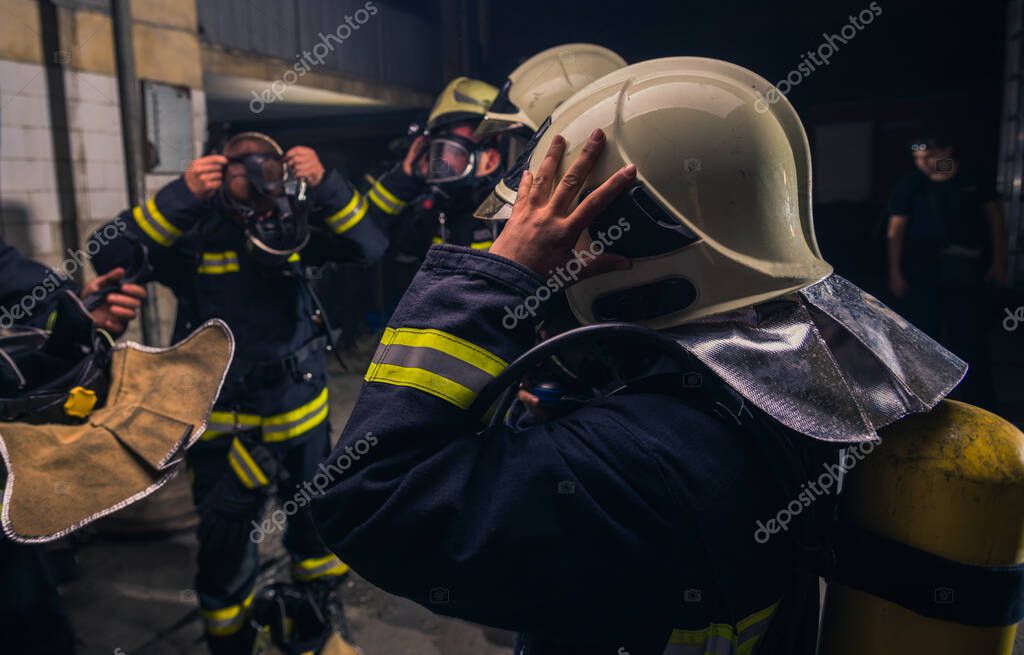 Grupo de bomberos de pie dentro de la brigada de bomberos con casco y ...