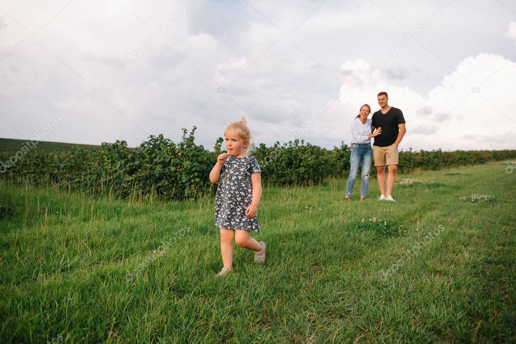 Feliz familia caminando por el parque. Mamá, papá e hija caminan al ...