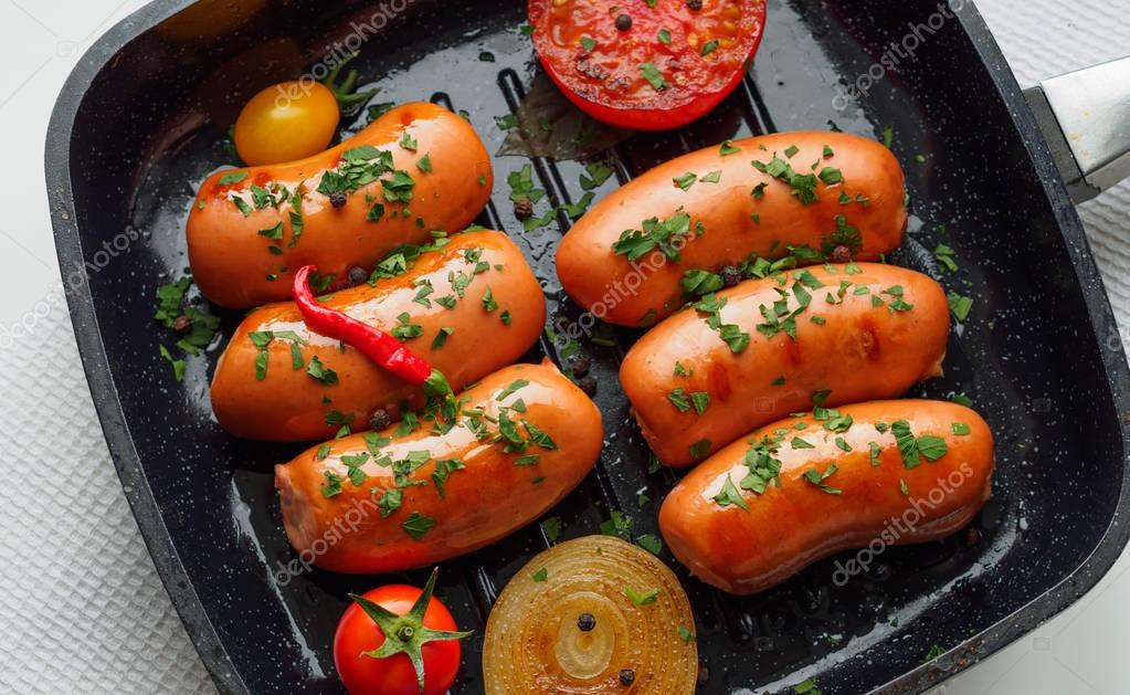 Embutidos fritos con hierbas y verduras en sartén al fondo blanco 2024