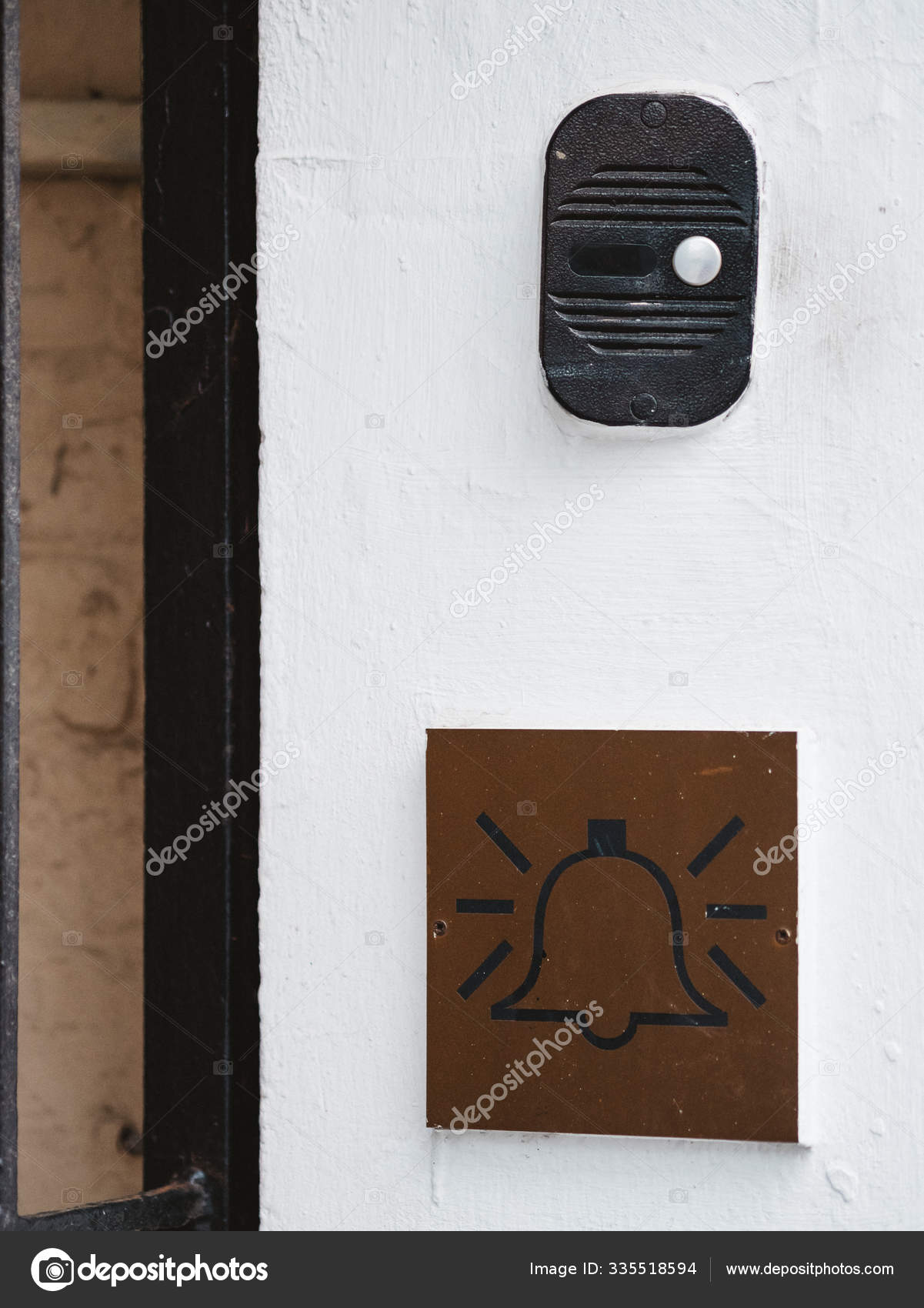 The intercom on the white wall of the house and the emblem with a bell ...