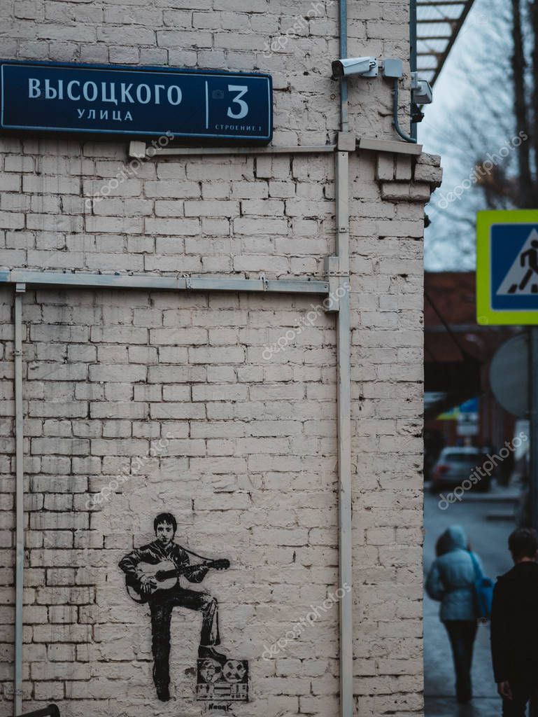 Imagen de Visotsky con guitarra y grabadora en la pared de ladrillo de ...