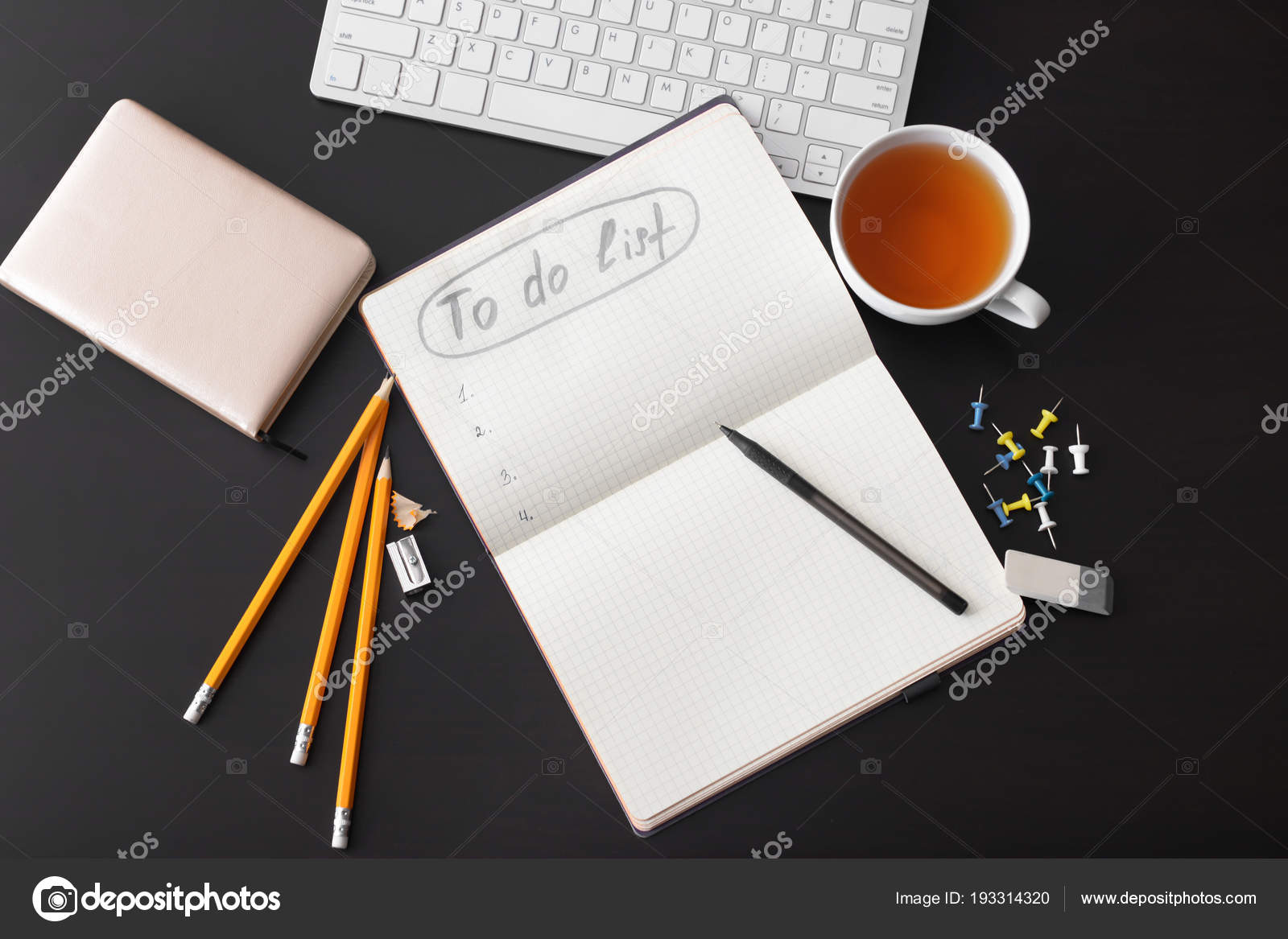 Empty to-do list, computer keyboard and cup of tea on dark background ...