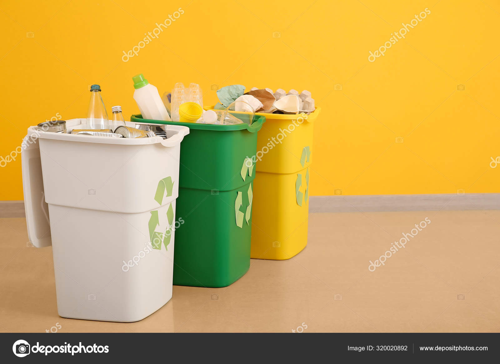 Containers with different types of garbage near color wall. Recycling ...