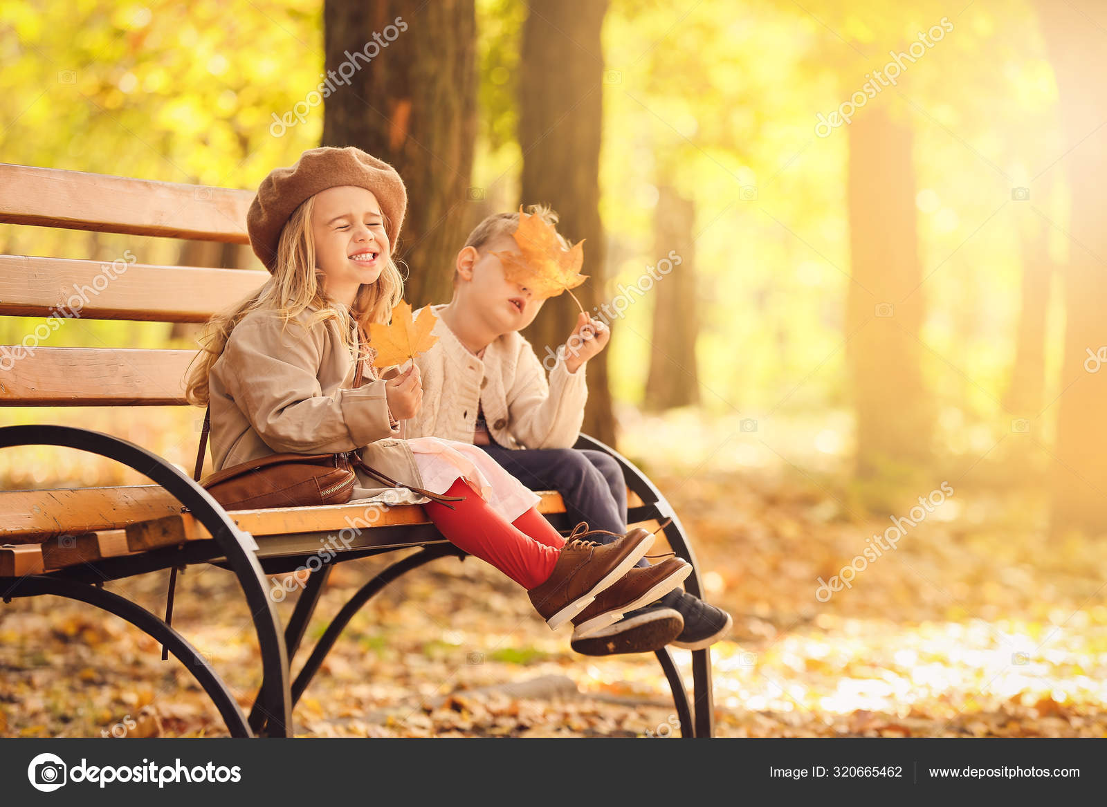 Cute little children sitting on bench in autumn park — Stock Photo ...