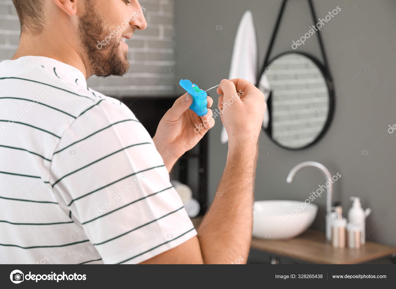 Handsome man flossing teeth in bathroom Stock Photo by ©serezniy 328265438