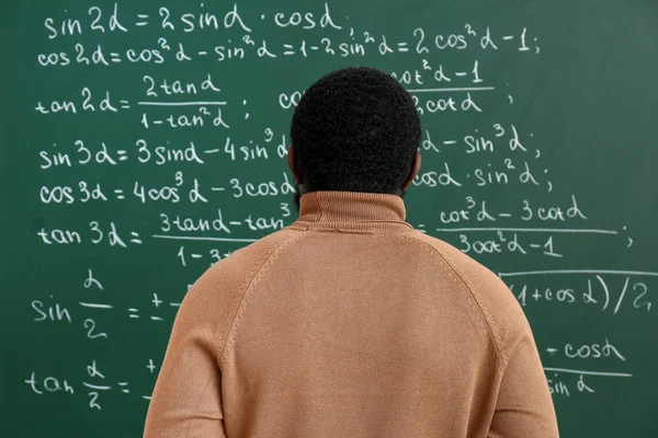 African-American math teacher near blackboard in classroom - Stock ...