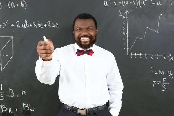 African-American math teacher near blackboard in classroom - Stock ...