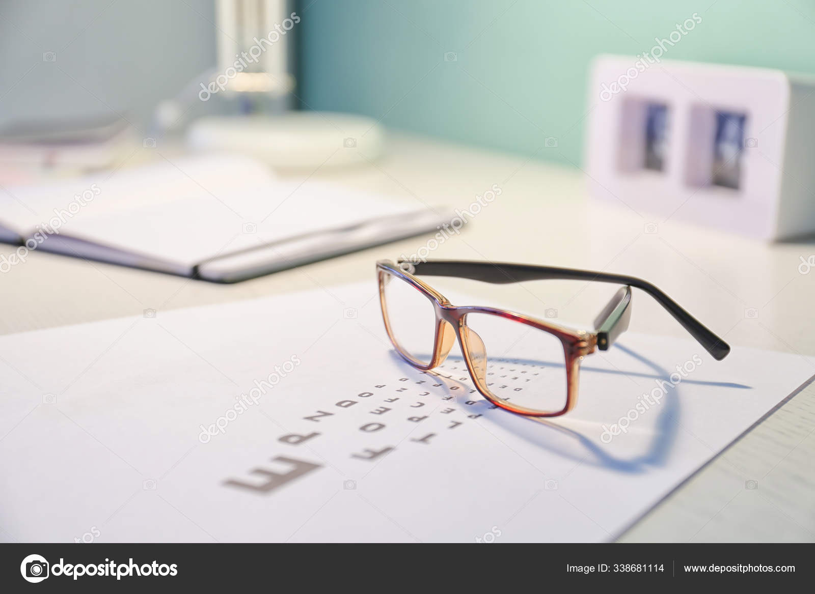 Glasses with eye test chart on table in ophthalmology clinic Stock ...