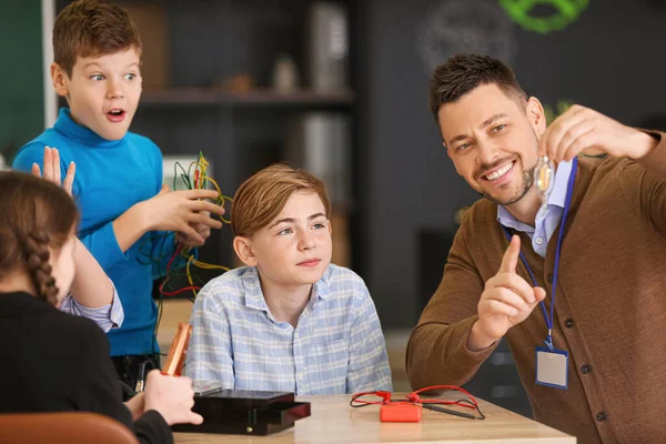 Teacher conducting physics lesson in classroom - Stock Image - Everypixel